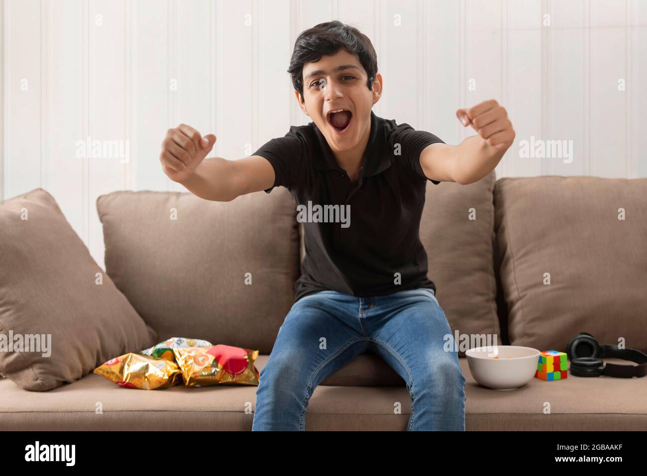 AN EXCITED TEENAGER EXPRESSING HAPPINESS WHILE EATING SNACKS Stock ...