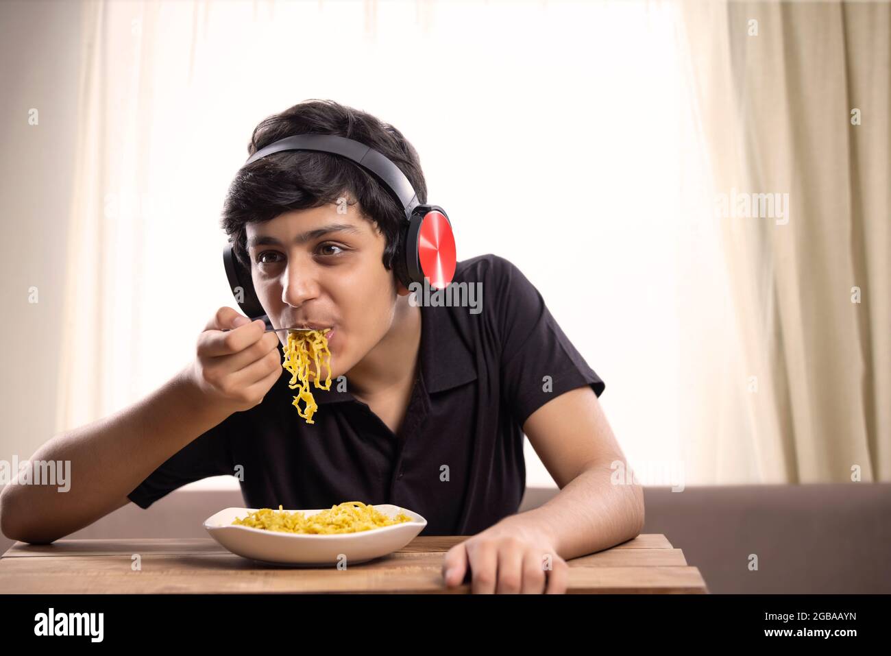 A SMART TEENAGE BOY HAPPILY EATING MAGGI Stock Photo - Alamy