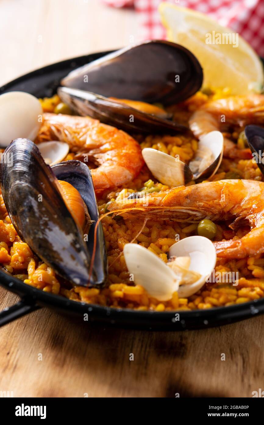 Traditional spanish seafood paella on wooden table Stock Photo - Alamy
