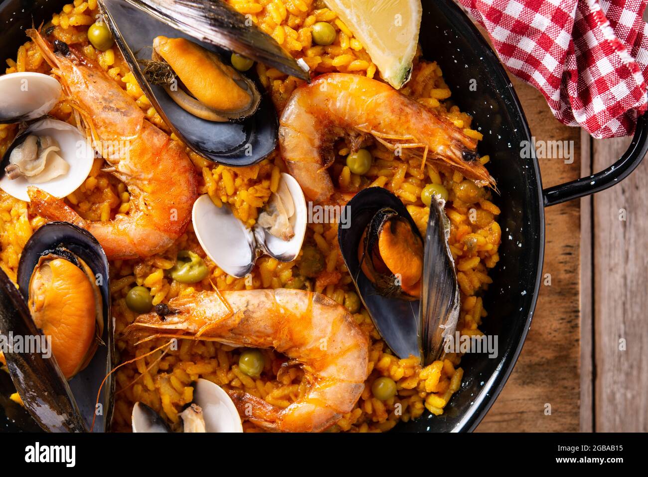 Traditional spanish seafood paella on wooden table Stock Photo - Alamy