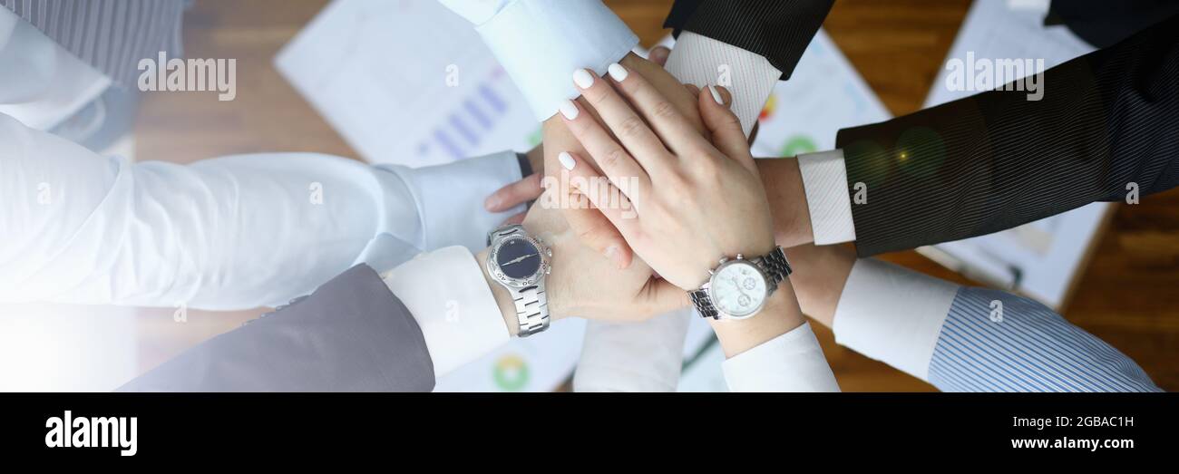 Business people put their hands together over table Stock Photo - Alamy