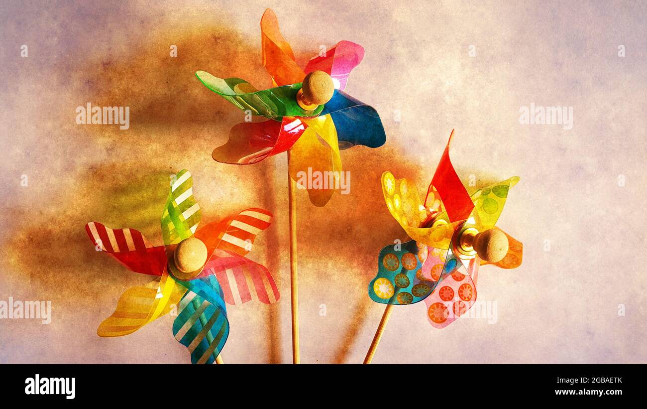 Three toy windmills on stylised background Stock Photo - Alamy