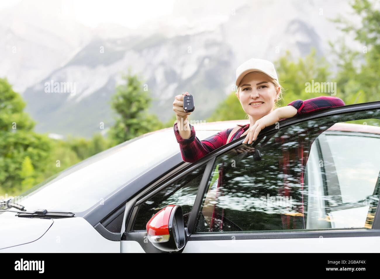 Happy driver woman against mountains background. Summer vacations ...