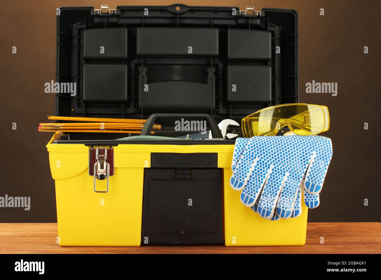 Open yellow tool box with tools on brown background close-up Stock ...