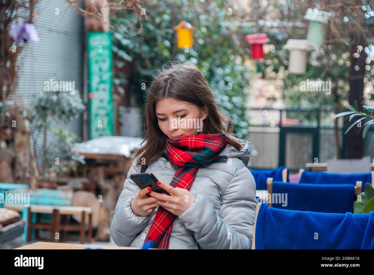 Young woman texting on a smart phone in cafe Stock Photo - Alamy