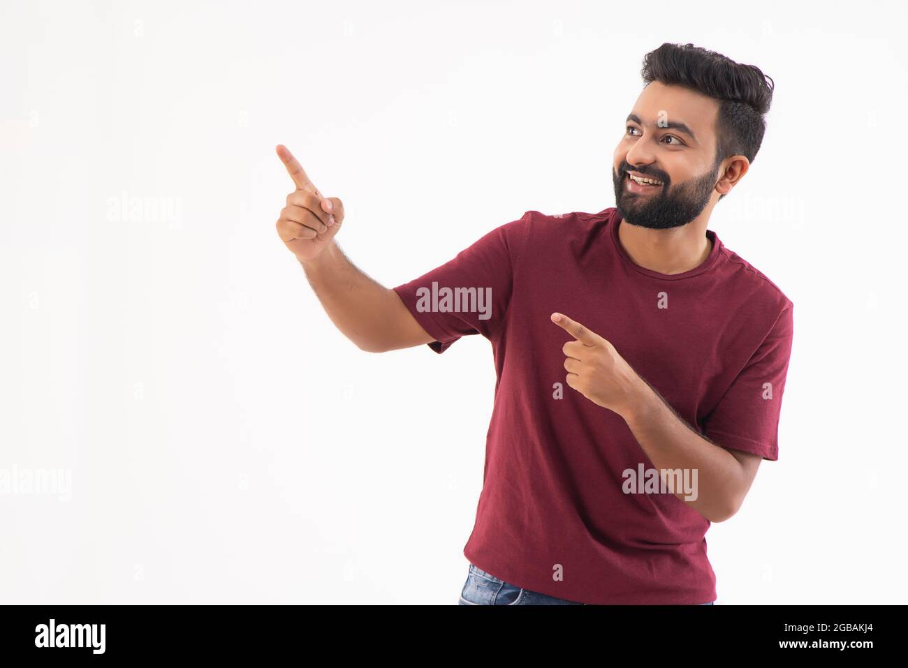 A CHEERFUL YOUNG MAN HAPPILY POINTING ABOVE Stock Photo - Alamy