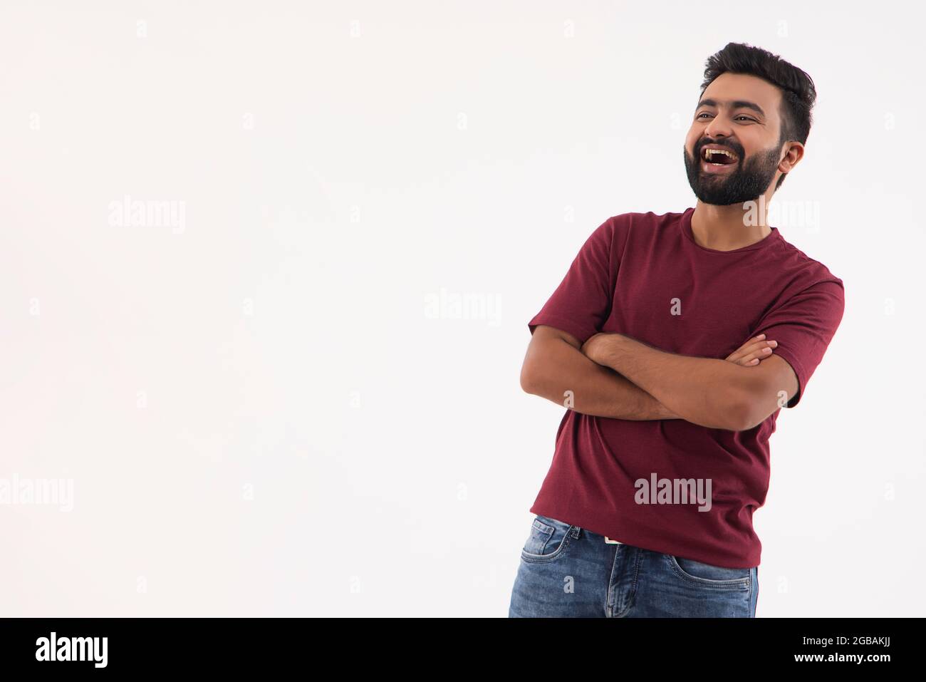 A BEARDED MAN STANDING WITH HANDS CROSSED AND LAUGHING Stock Photo - Alamy