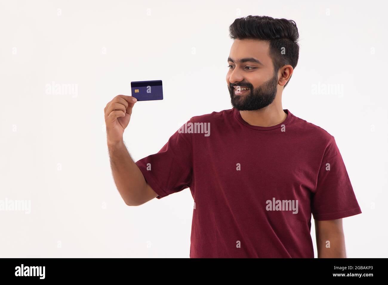 A BEARDED YOUNG MAN LOOKING AT DEBIT CARD IN HAND Stock Photo - Alamy