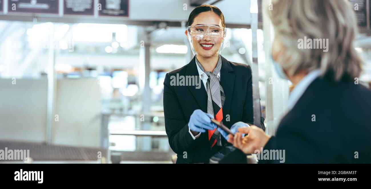 Airport security personnel checking in passenger. Ground attendant ...