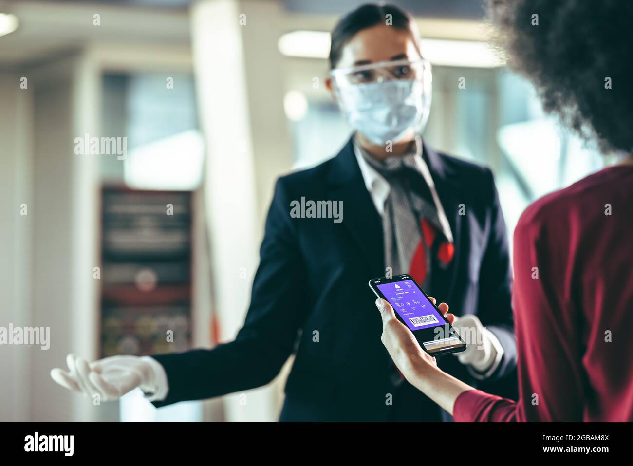 Woman passenger holding smart phone with boarding pass standing at ...