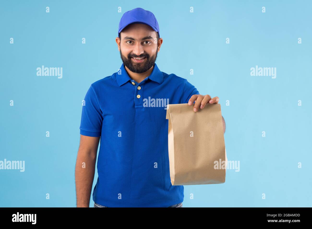 A BEARDED YOUNG DELIVERY MAN HOLDING PACKED FOOD Stock Photo - Alamy
