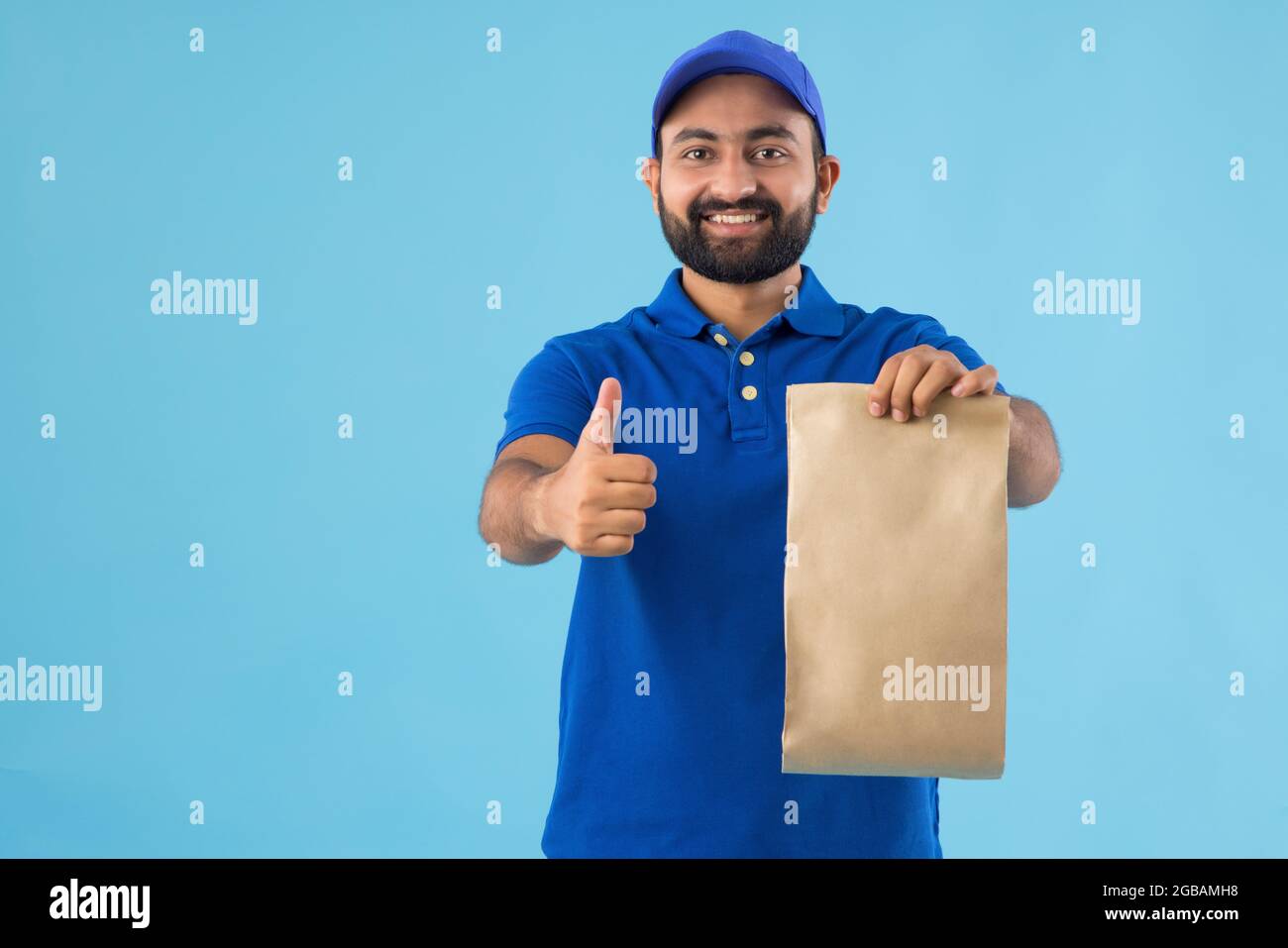A BEARDED DELIVERY GUY SHOWING THUMBS UP WHILE HOLDING FOOD PACKET ...