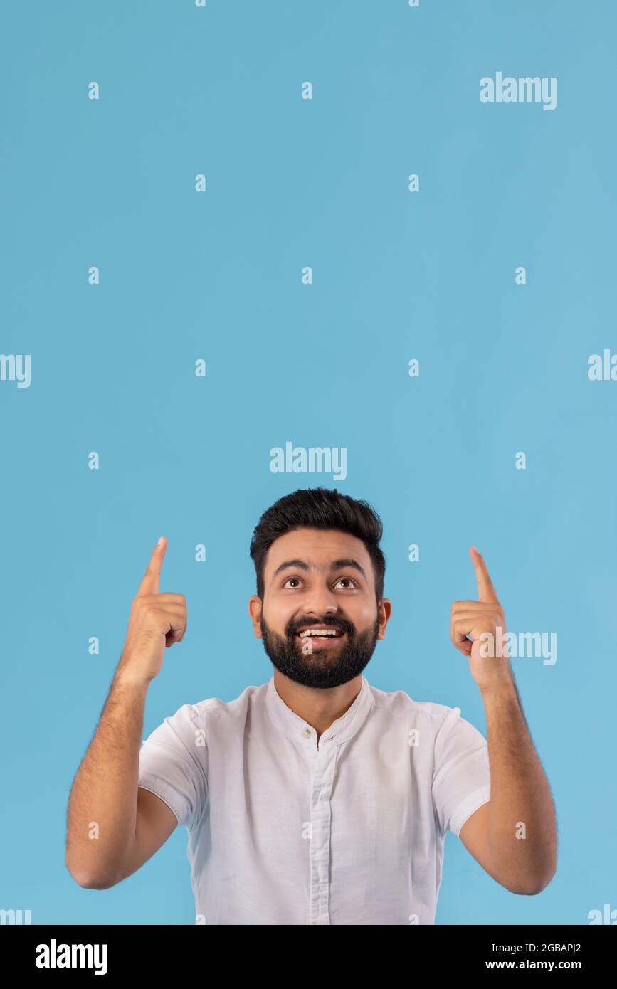 A HAPPY BEARDED MAN POINTING FINGERS ABOVE Stock Photo - Alamy