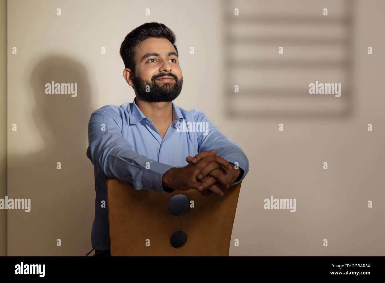 PORTRAIT OF A SMART YOUNG MAN SITTING AND HAPPILY LOOKING ABOVE Stock ...