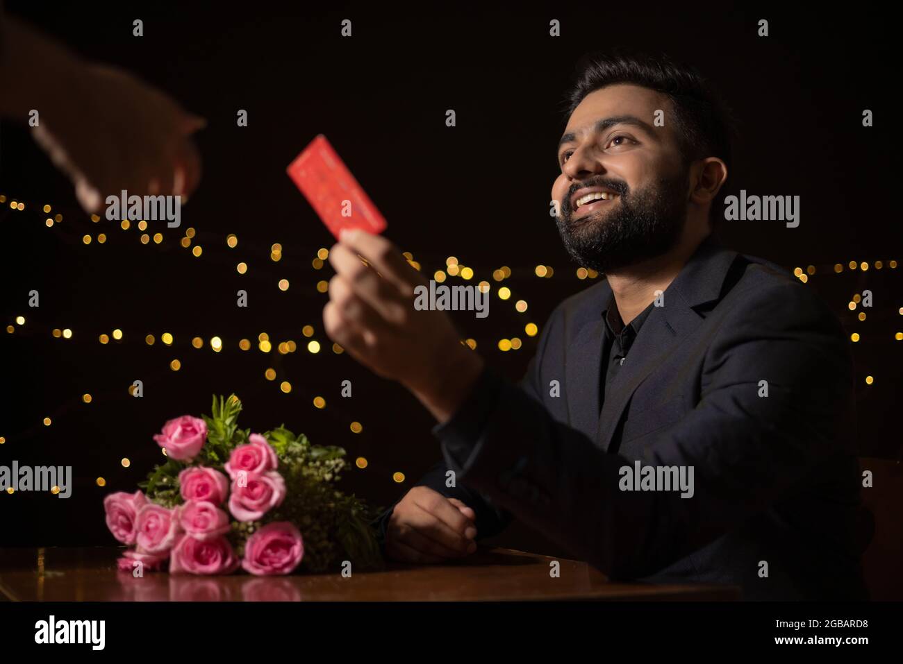 A BEARDED YOUNG MAN PAYING USING DEBIT CARD IN A PARTY Stock Photo - Alamy