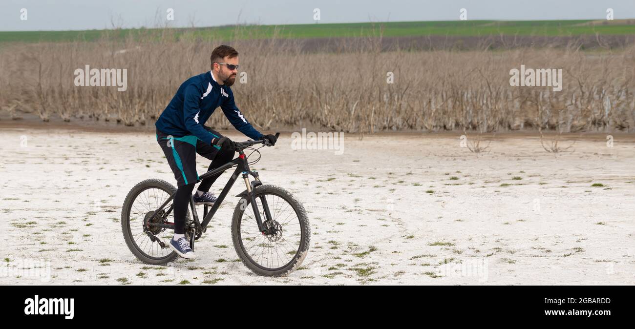 panorama cyclist on a mountain bike on a salt beach on a background of ...