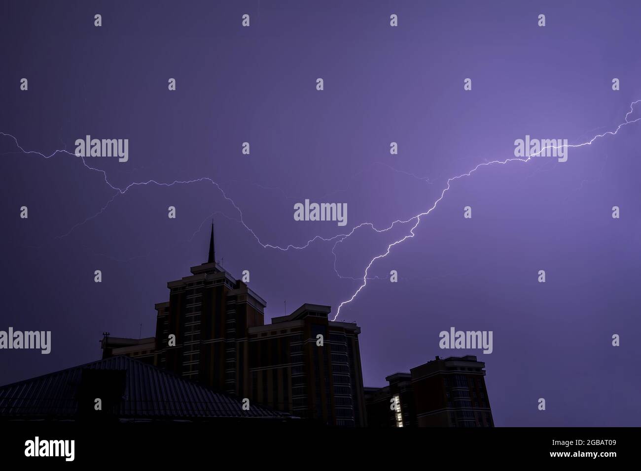 Colorful flash of lightning against the dark night sky above the roof ...