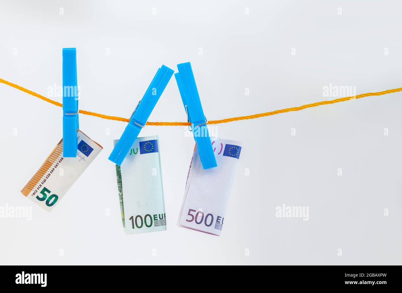 euro banknotes attached with clothespins to a rope on white isolated ...