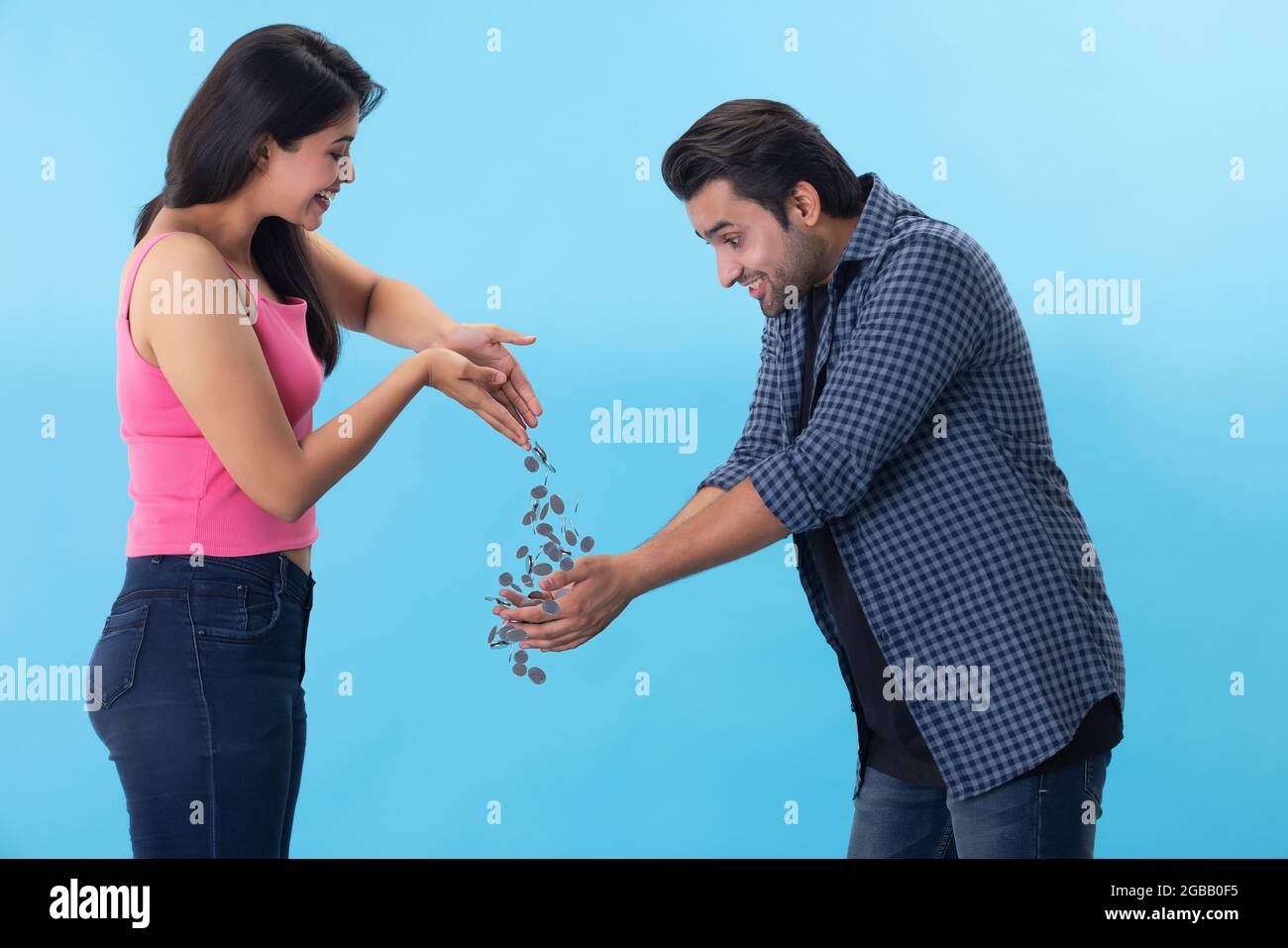 A young man catching coins dropping from woman's hands Stock Photo - Alamy