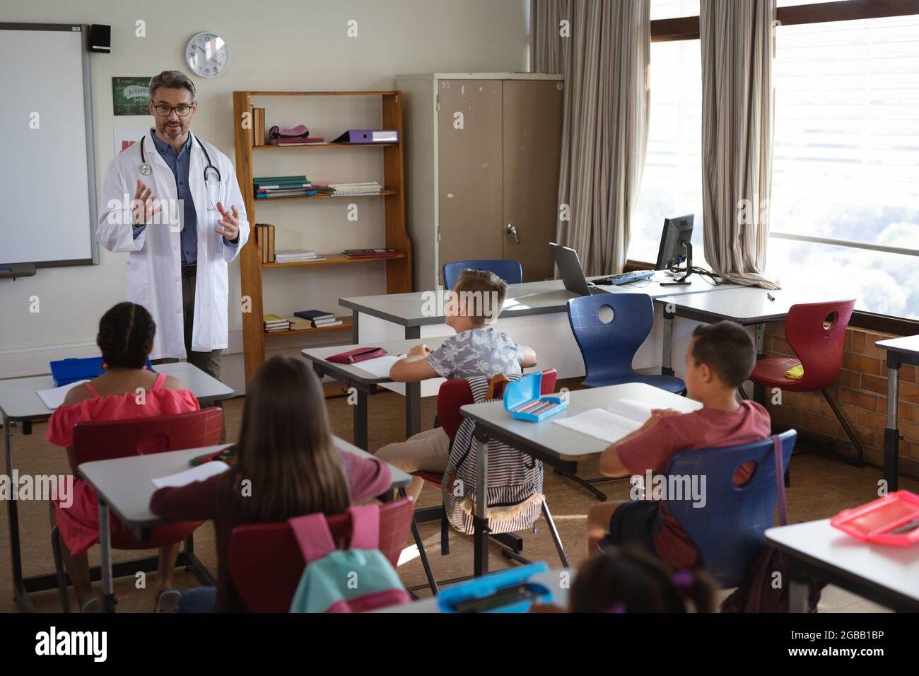 Caucasian male doctor talking to group of diverse students sitting in ...
