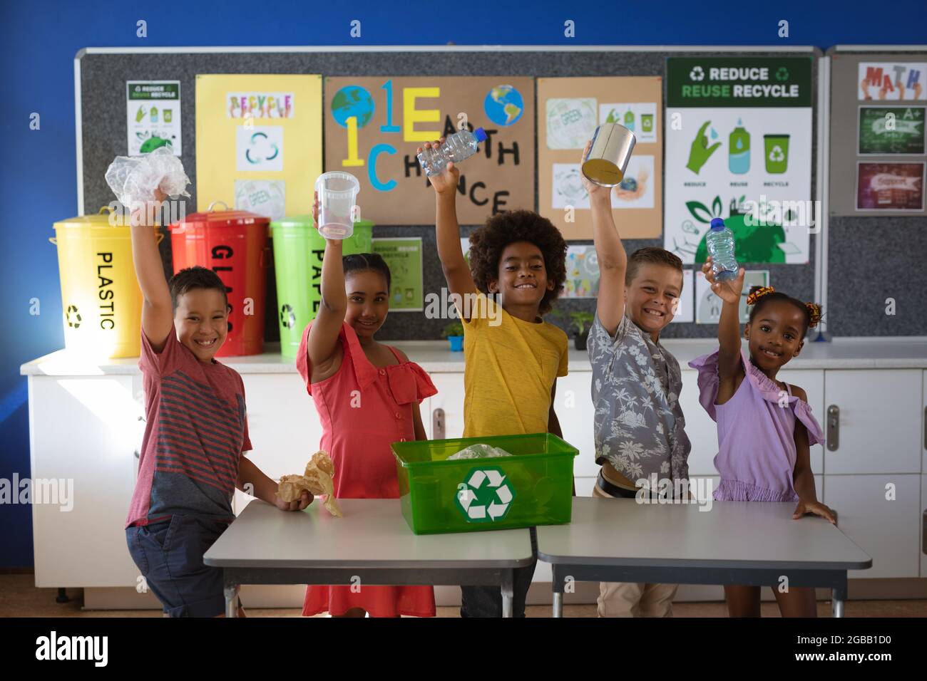 Portrait of group of diverse students smiling while holding recyclable ...