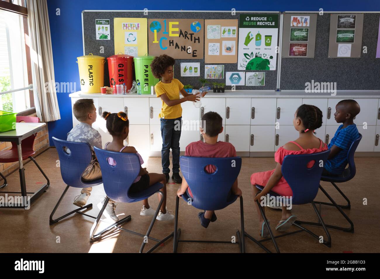 African american boy showing how to recycle plastic items to other ...