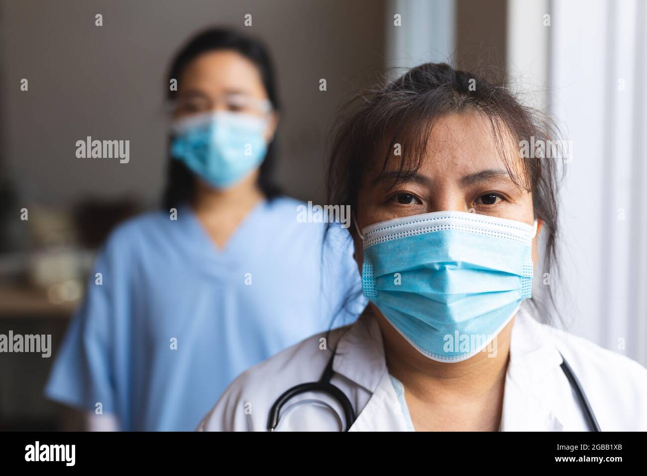 Portrait of two asian female doctors wearing face masks at home Stock ...
