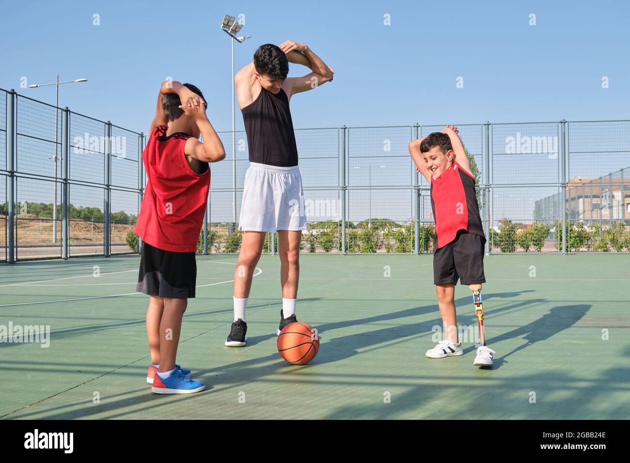Basket coach arm stretching with two children, one has a prosthesis ...