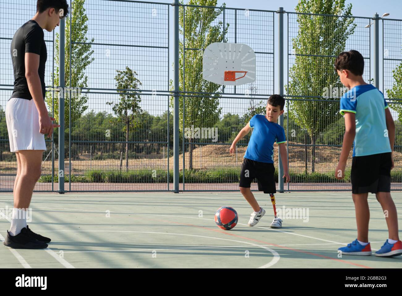 Couch playing football with two students. One of them has a leg ...