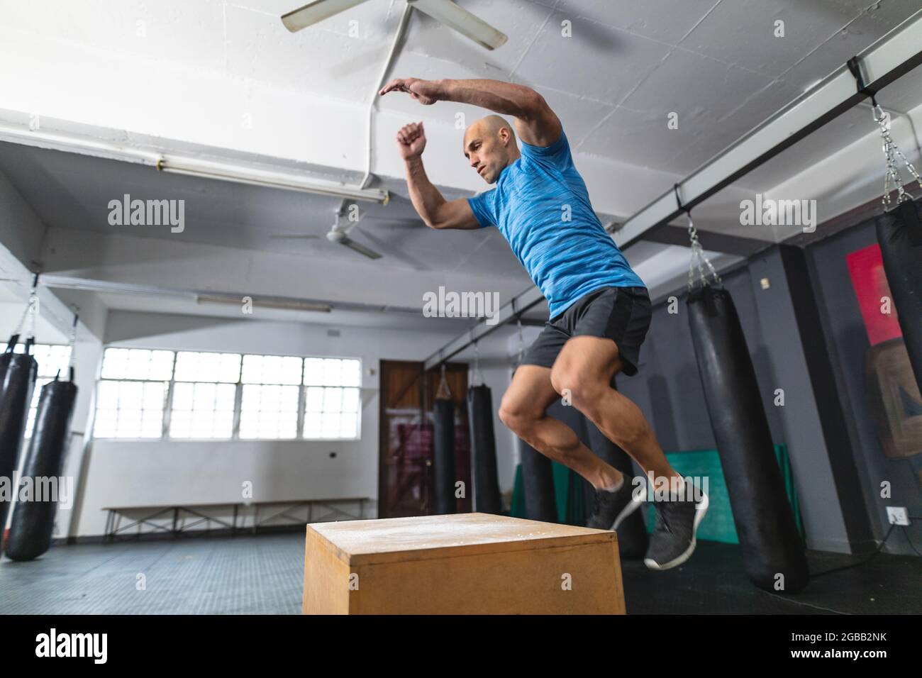 Caucasian man exercising at gym, jumping on box Stock Photo - Alamy
