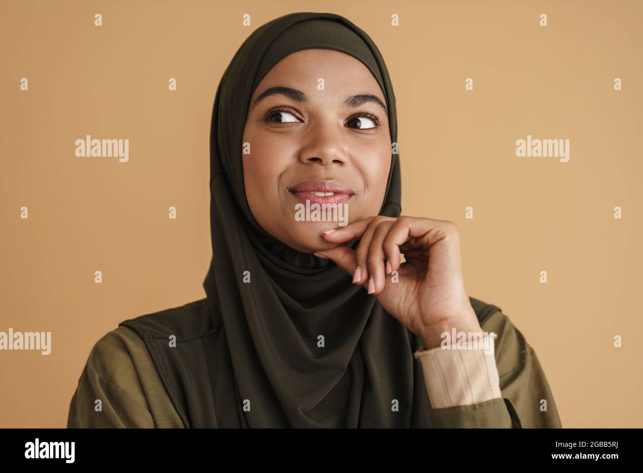 Black muslim woman in hijab smiling and looking aside isolated over ...
