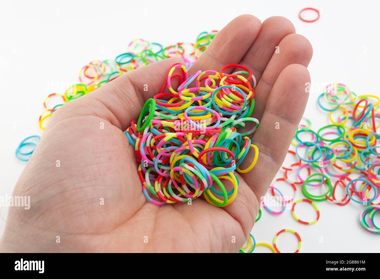 Isolated Color rubber band in hand Stock Photo - Alamy