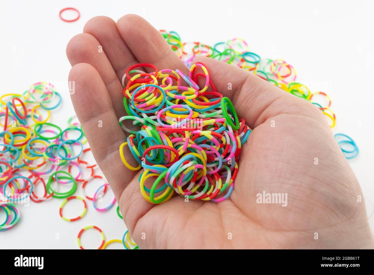 Isolated Color rubber band in hand Stock Photo - Alamy