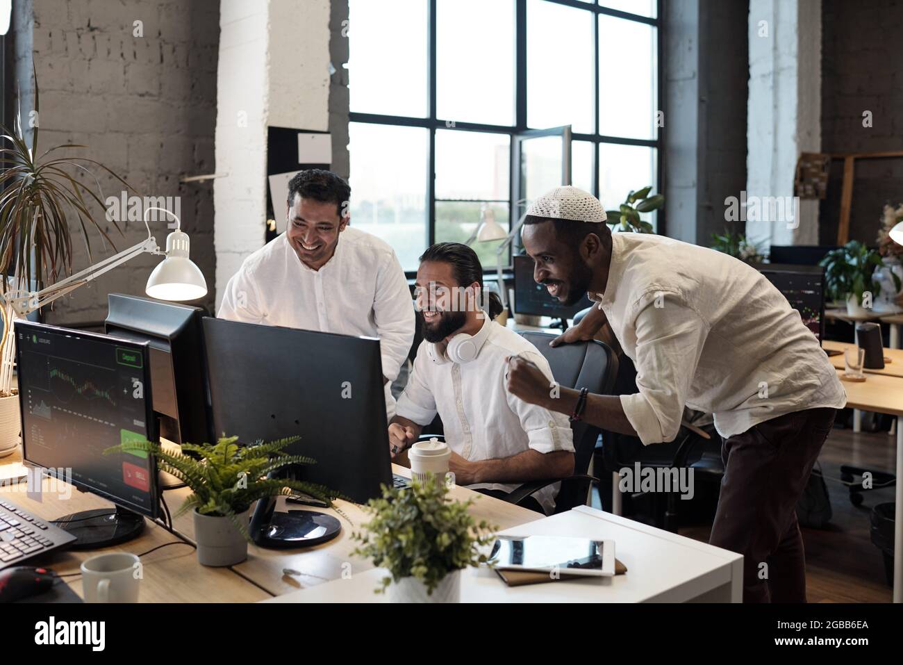Young successful businessmen looking at computer screen with smiles ...