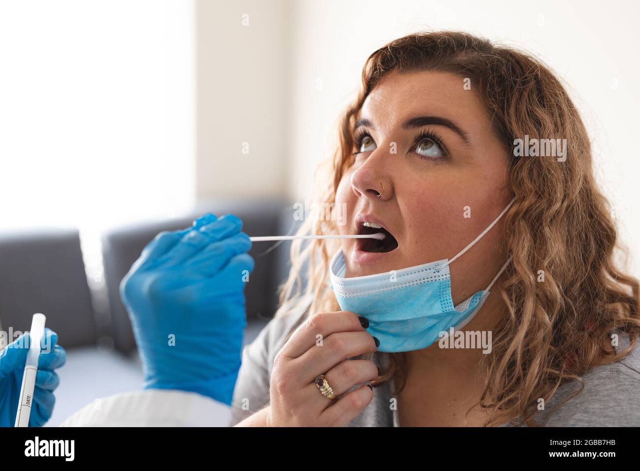Female doctor wearing medical gloves taking swab test from female ...