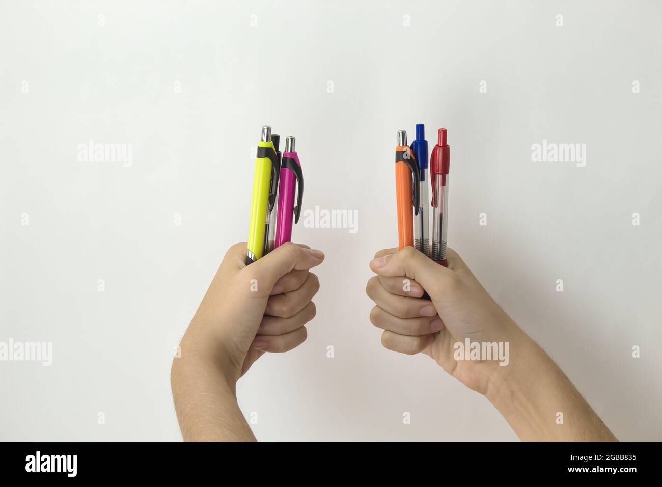 hands of a girl holding a handful of color pens on white background ...