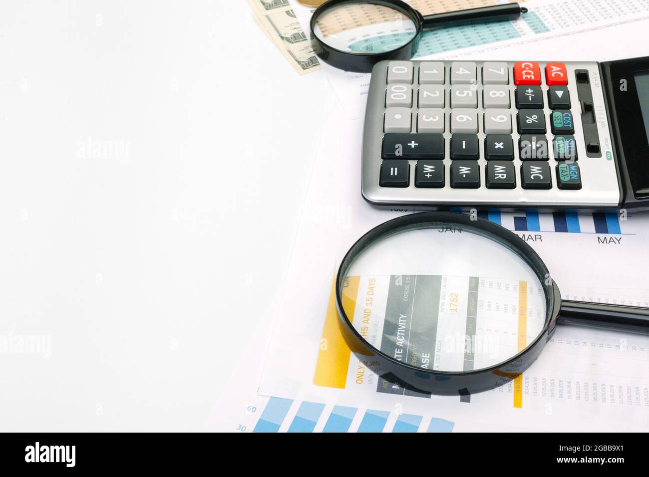 Business graph with magnifying glass on table Stock Photo - Alamy