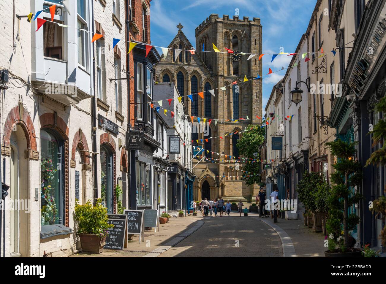 View of shops and cafes on Kirkgate and Cathedral in background, Ripon ...