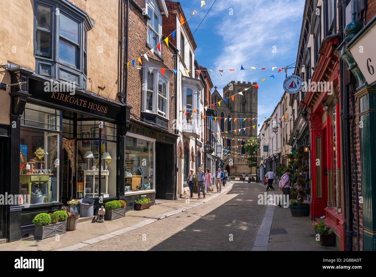 View of shops and cafes on Kirkgate and Cathedral in background, Ripon ...