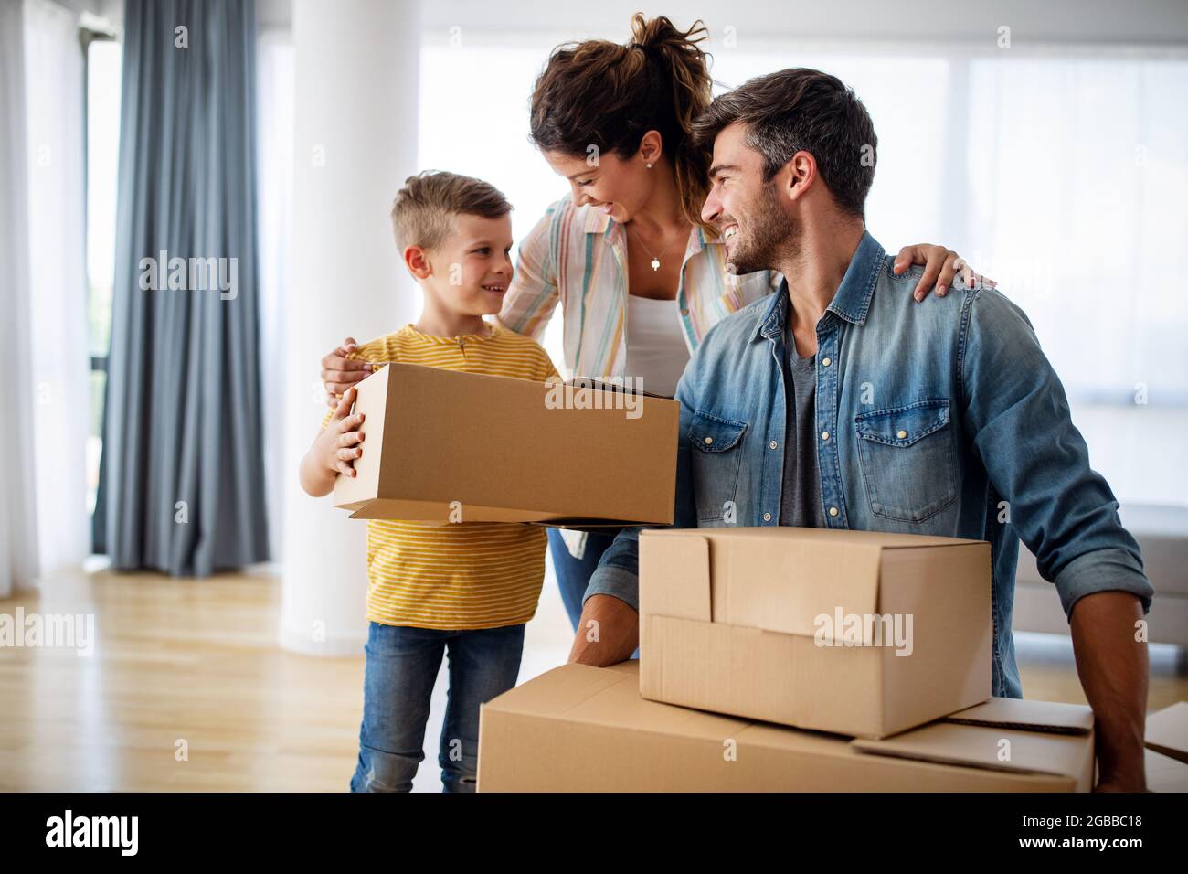 Happy family unpacking boxes in new home on moving day Stock Photo - Alamy