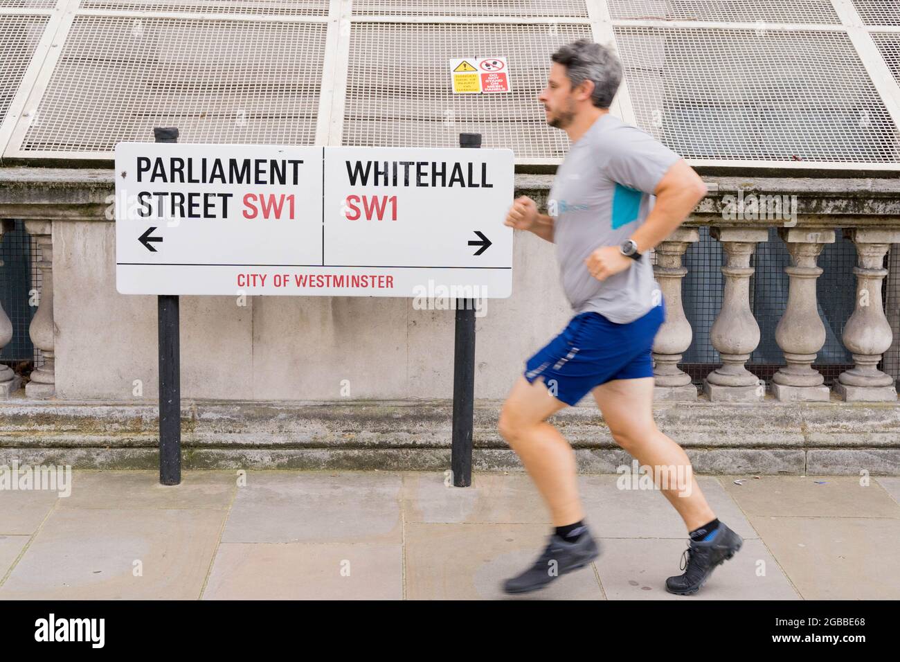 male runner on pavement running from WHITEHALL to Parliament Street ...
