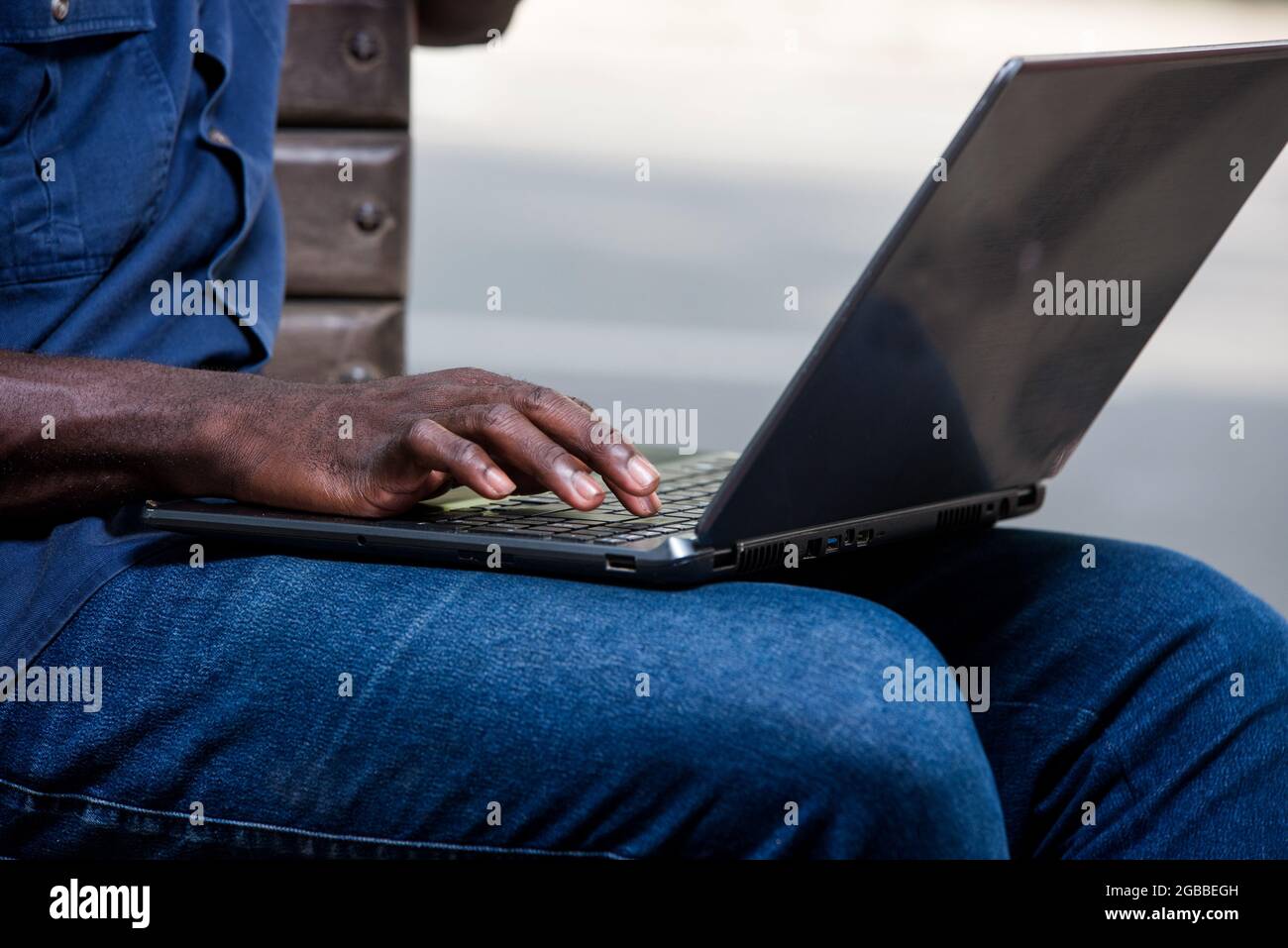 young man sitting outdoors doing research with laptop Stock Photo - Alamy