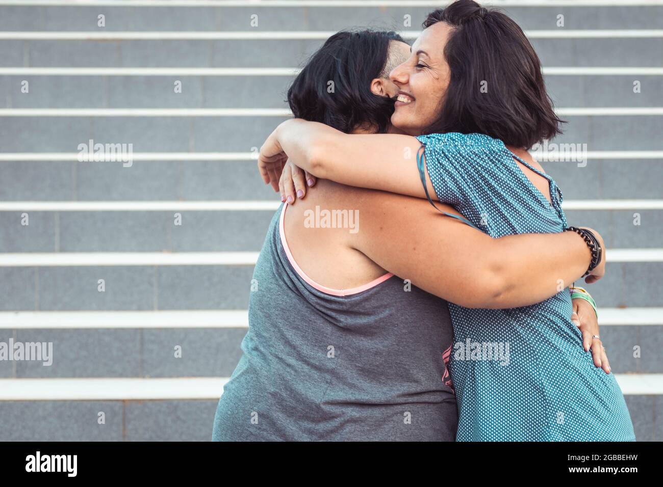 Two adult twin sisters hugging. Different styles Stock Photo - Alamy