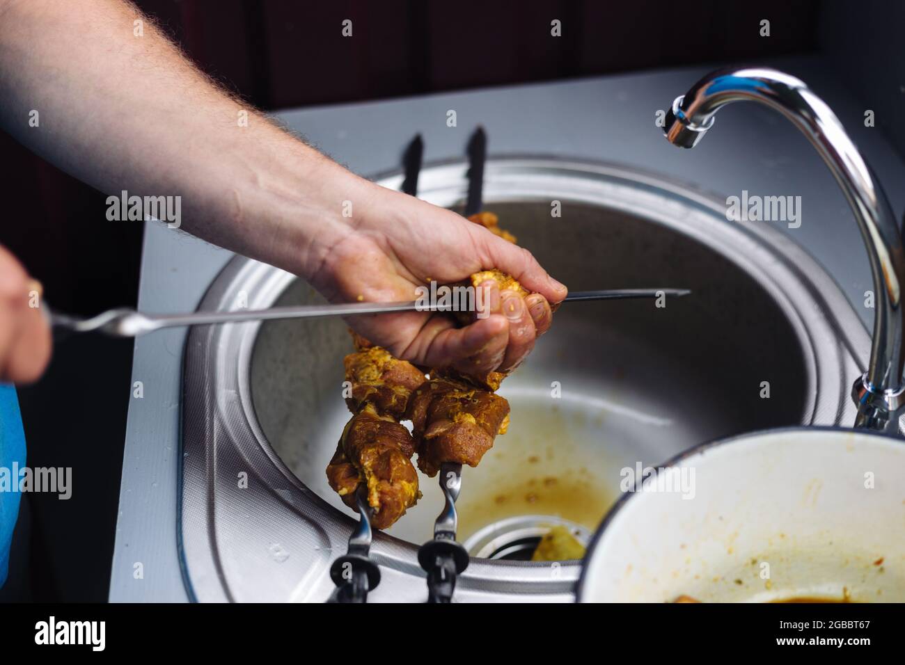 The chef stringing meat on skewers for cooking Stock Photo - Alamy