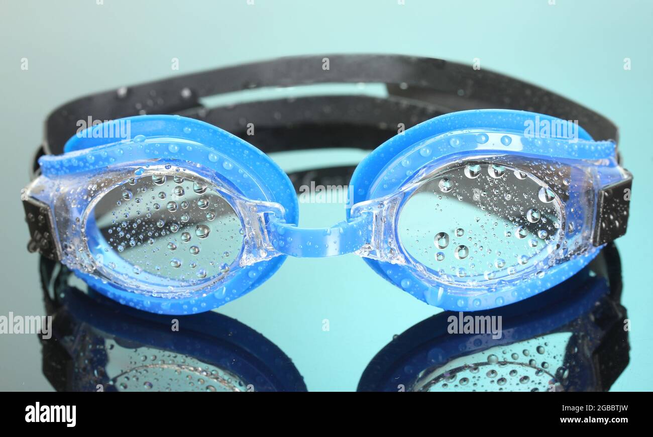 blue swim goggles with drops on blue background Stock Photo - Alamy