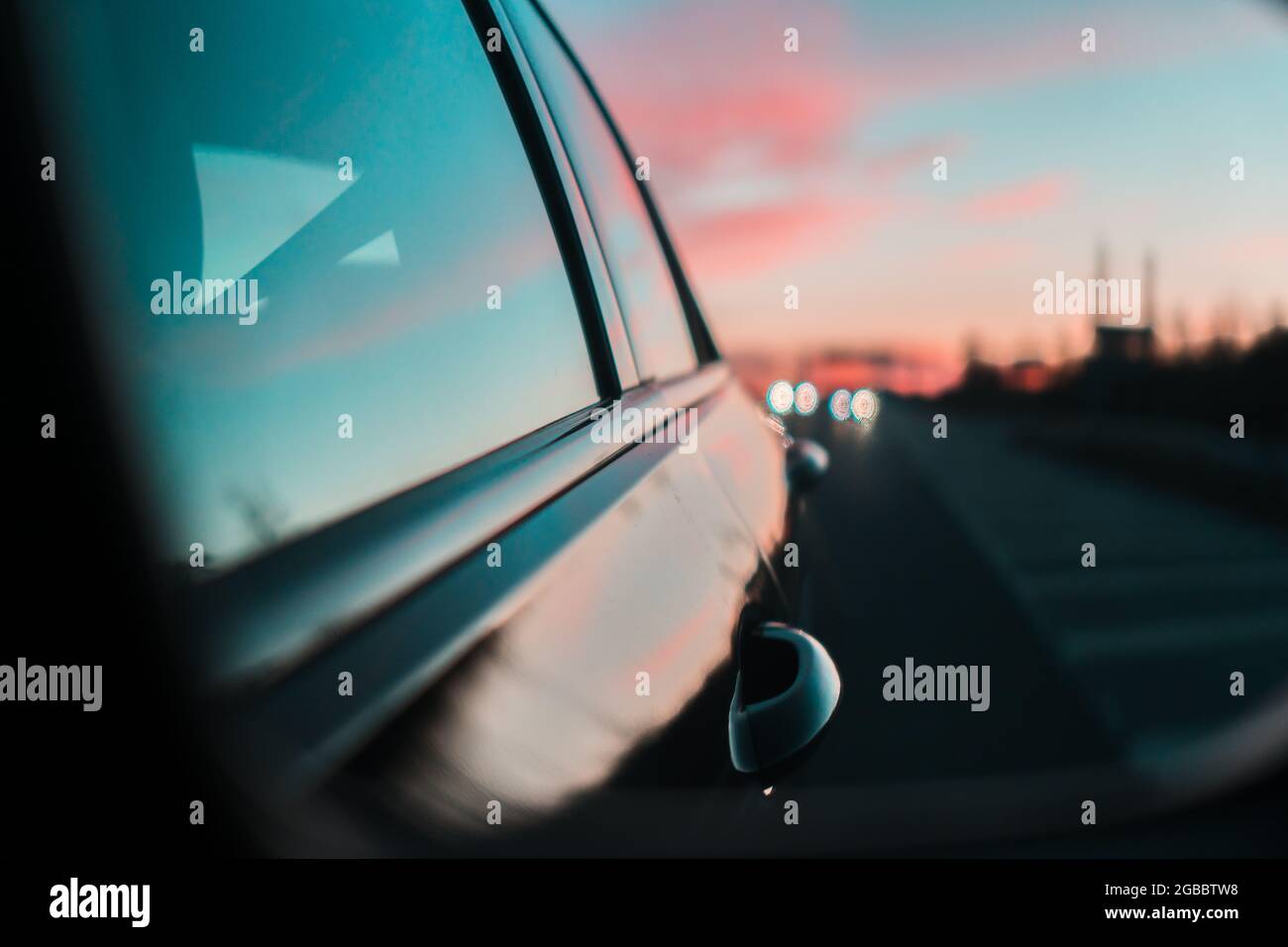 Reflection of the sunset clouds in the car mirror Stock Photo - Alamy