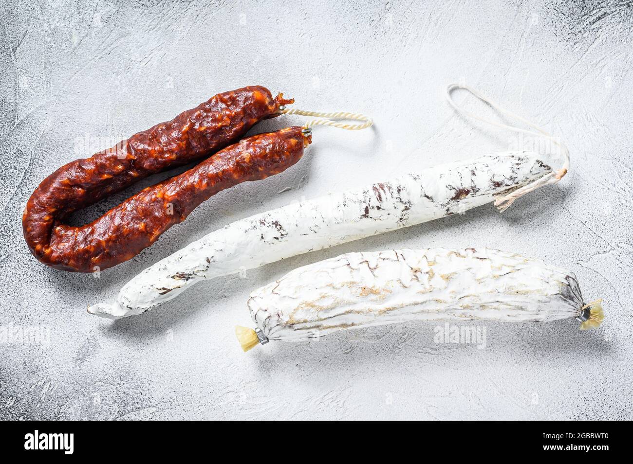 Spanish salami, fuet and chorizo sausages on a kitchen table. White ...