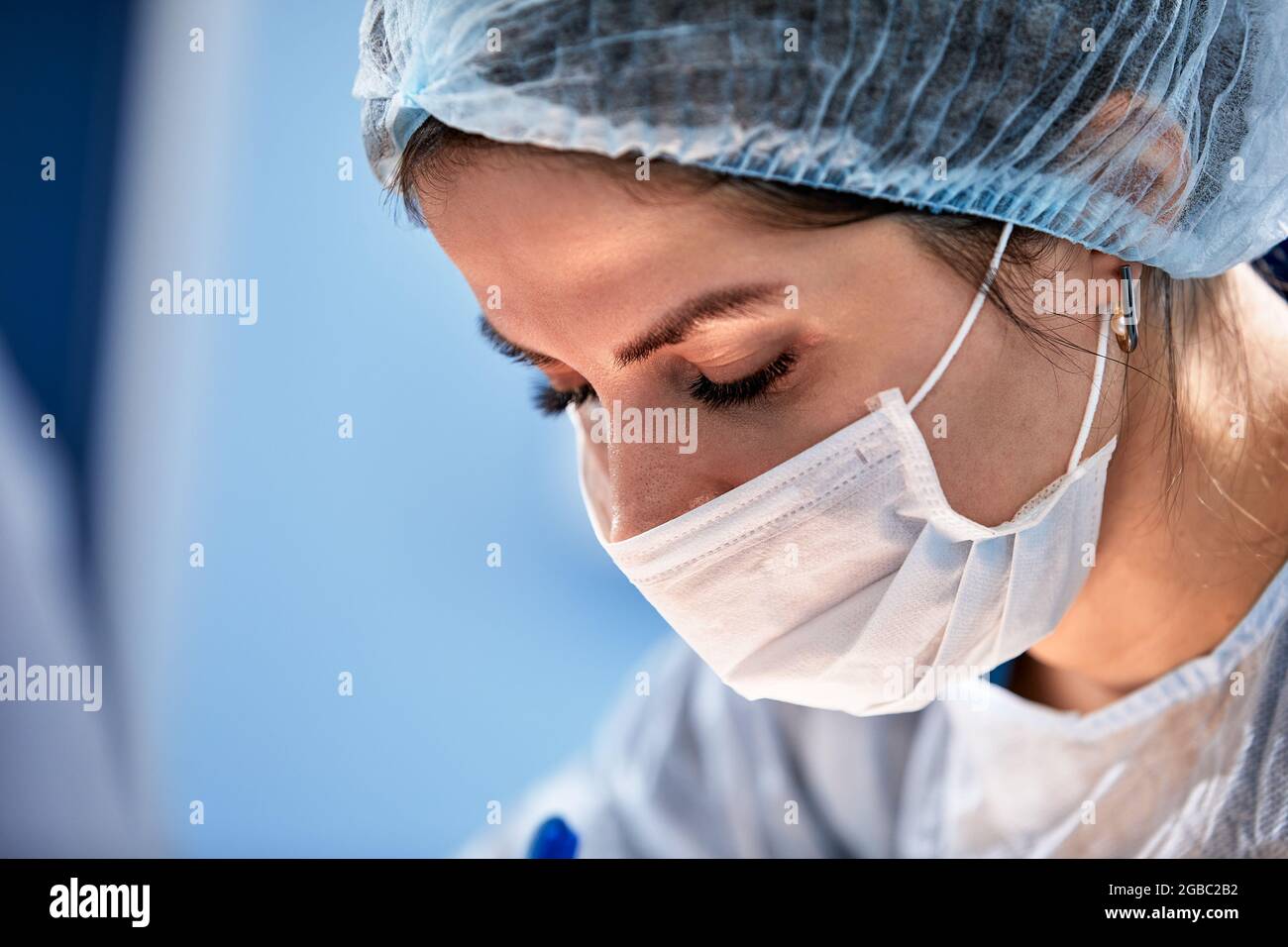 Female surgeon in operating room close-up, woman doctor face during ...