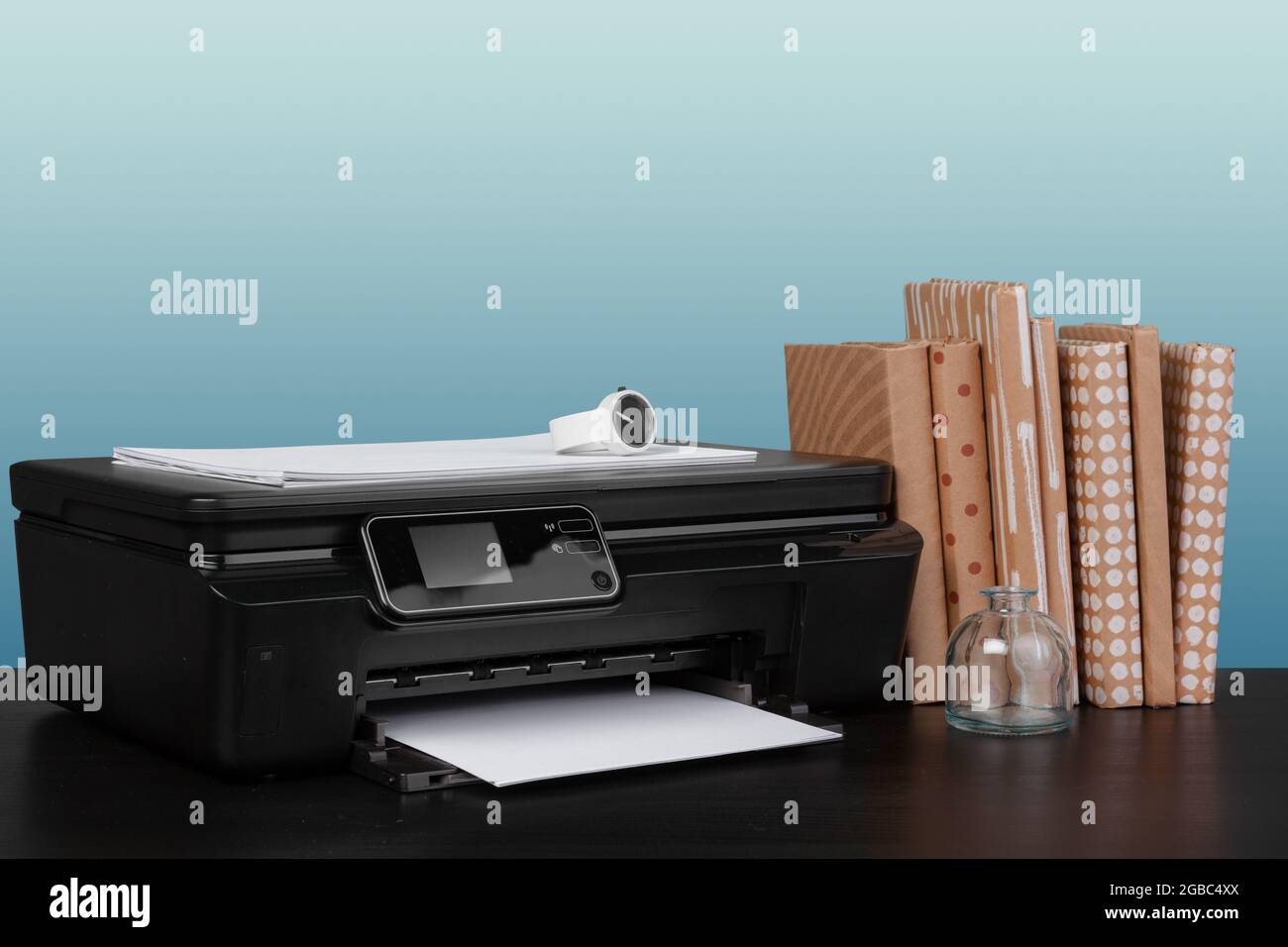 Compact laser printer on black desk against blue background Stock Photo ...