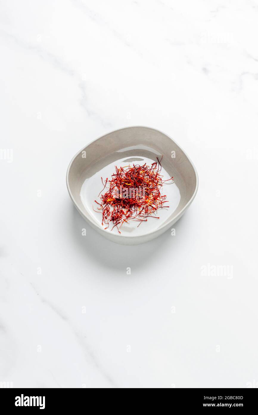 Saffron Threads Strands on Marble White Background with Package of ...